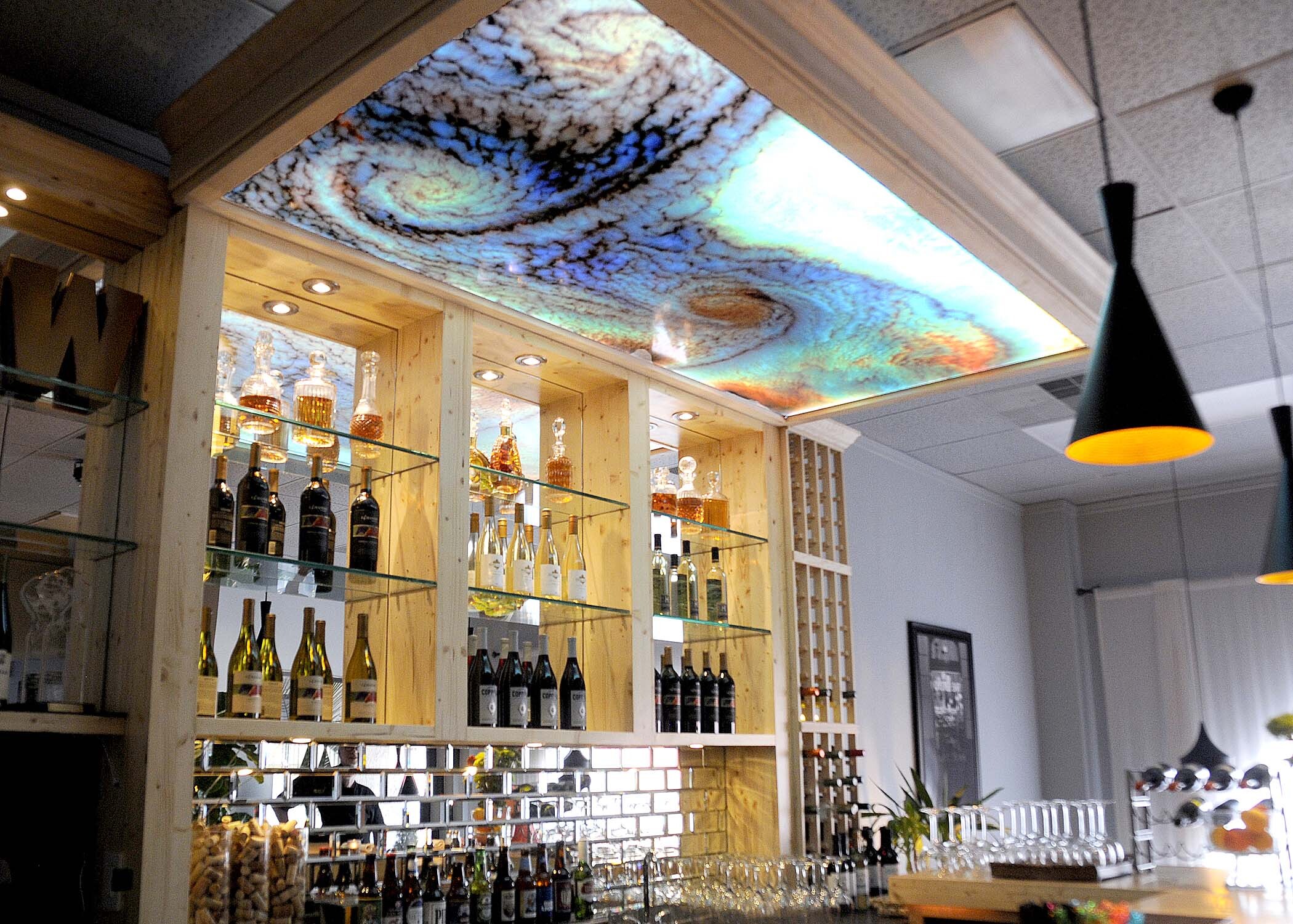 Decorative Ceiling Tiles Backlit graphic panel over a bar on the ...