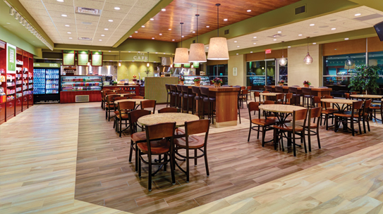 The interior of the Life Cafe with tables chairs and a counter to order ...